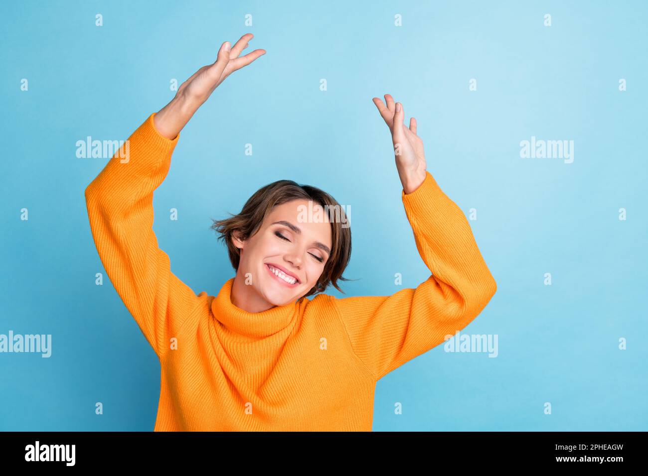 Photo portrait of cute young woman raise hands closed eyes dance ...