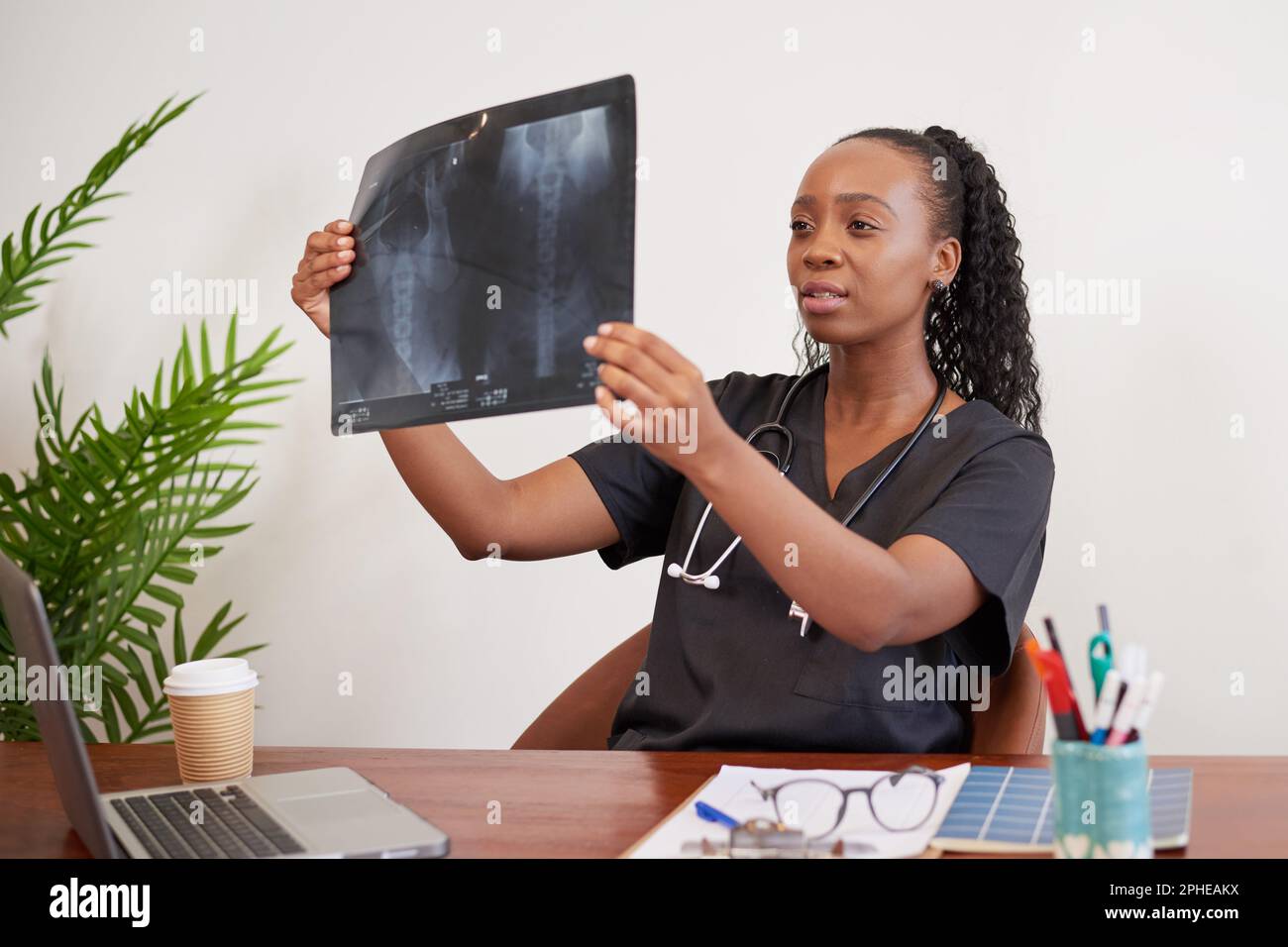 A Black female doctor examines patient x-ray of abdomen to diagnose ...