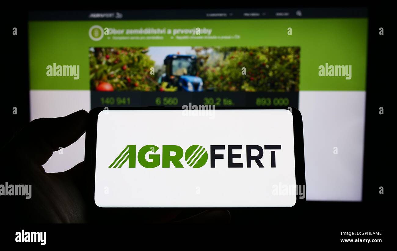 Person holding cellphone with logo of Czech company Agrofert a.s. on ...