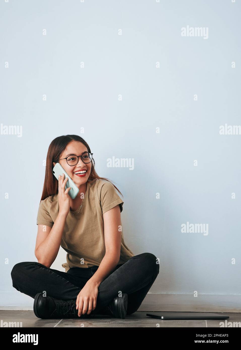 Phone call, floor and happy woman talking in home by wall background with mockup. Cellphone ...