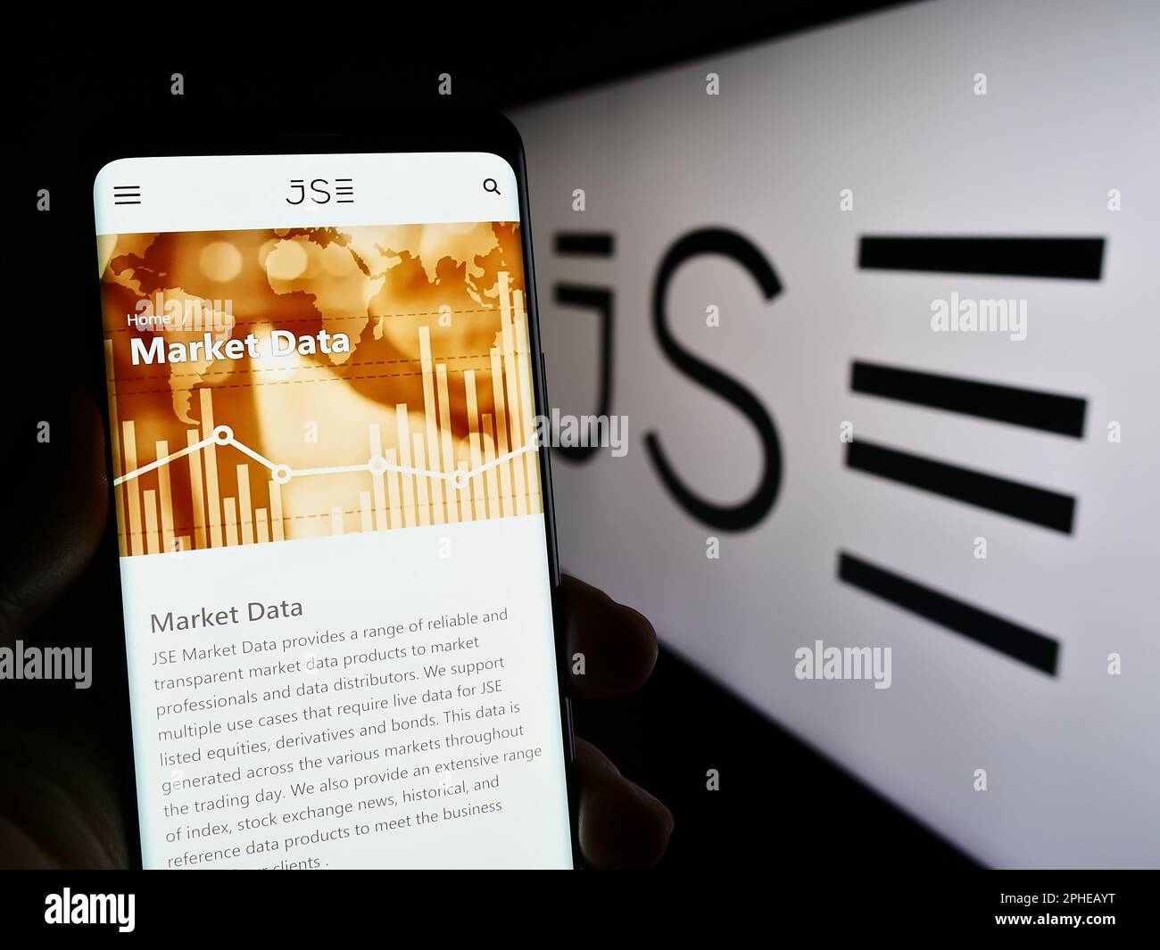 Person holding smartphone with webpage of JSE Limited (Johannesburg ...