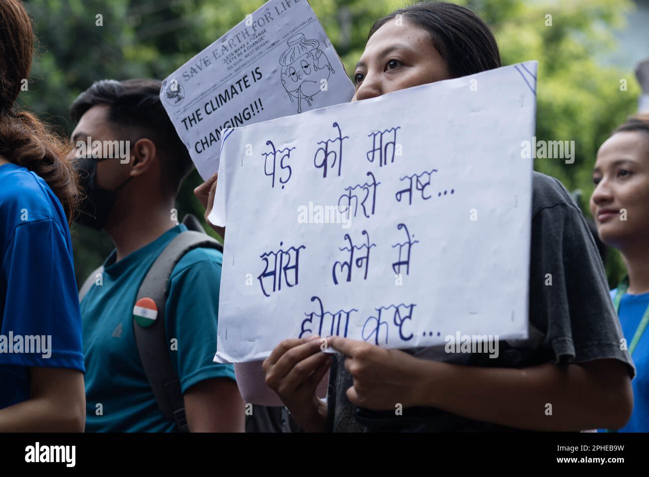 A woman stands in the street with a sign in hand, surrounded by a group ...
