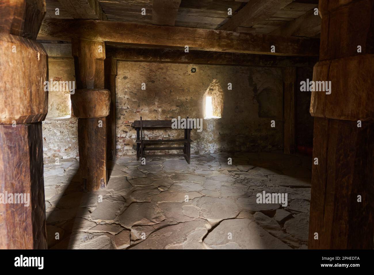 Ancient cellar with pavement slabs and worn wooden pillars Stock Photo ...
