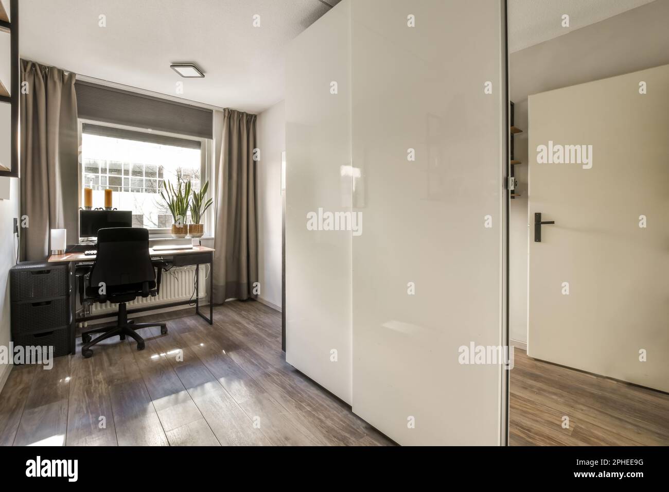 Interior design of contemporary home office with white wardrobe and ...