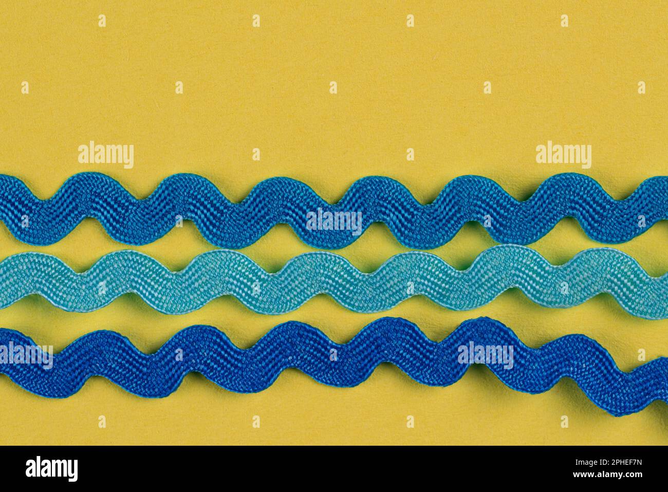 Closeup bunch of wave blue ribbons on yellow background Stock Photo - Alamy