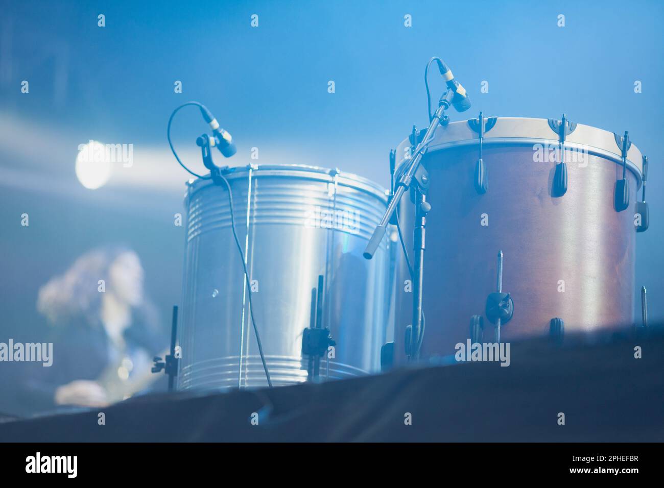 Two drums with professional microphones standing on edge of music stage ...