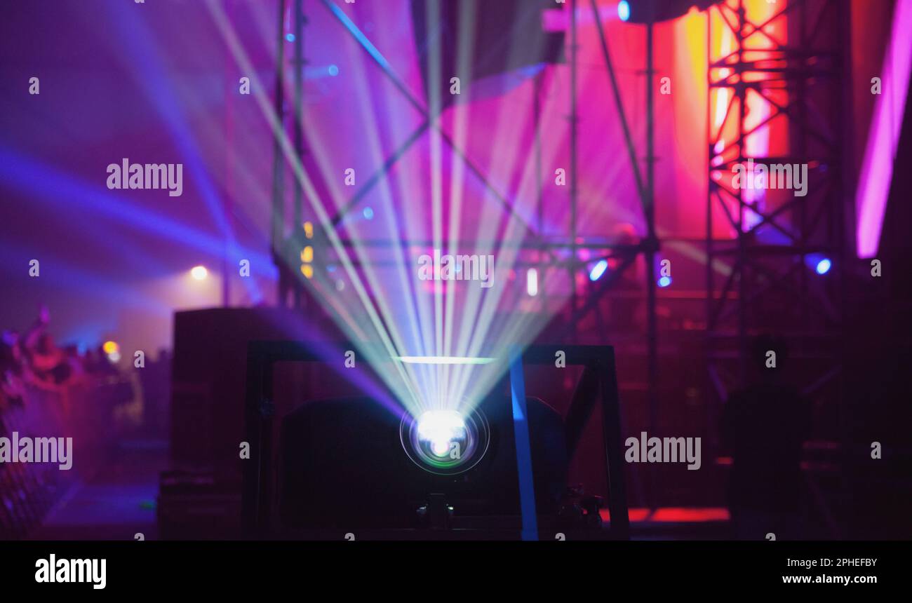 Colorful beams of bright laser light illuminating music venue during ...