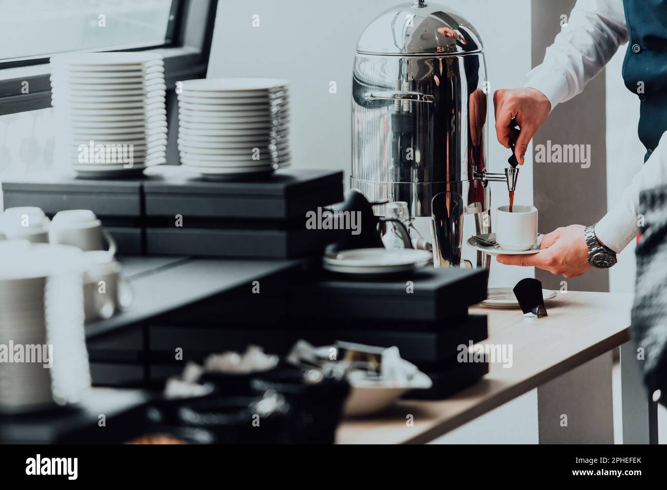 The waiter preparing coffee for hotel guests. Close up photo of service ...
