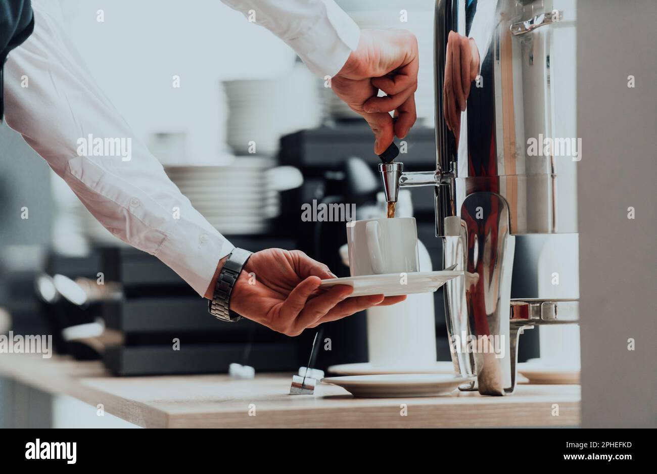 The waiter preparing coffee for hotel guests. Close up photo of service ...