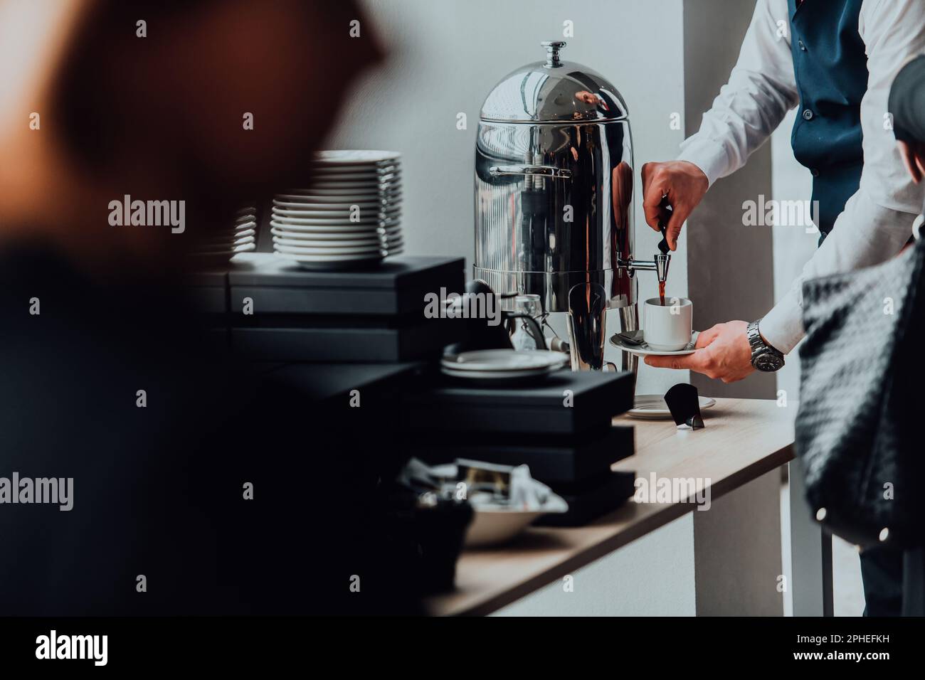The waiter preparing coffee for hotel guests. Close up photo of service ...