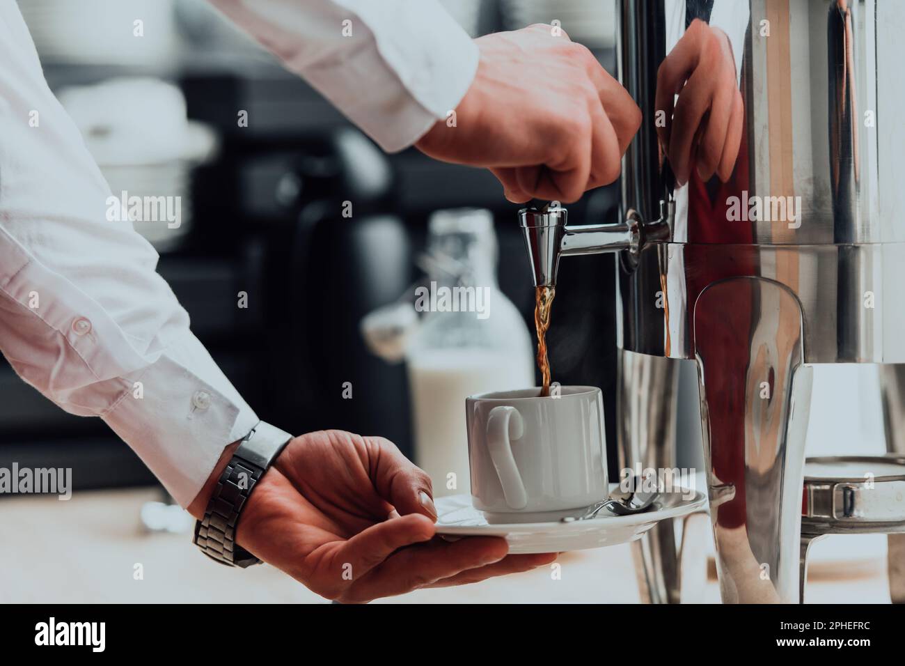 The waiter preparing coffee for hotel guests. Close up photo of service ...