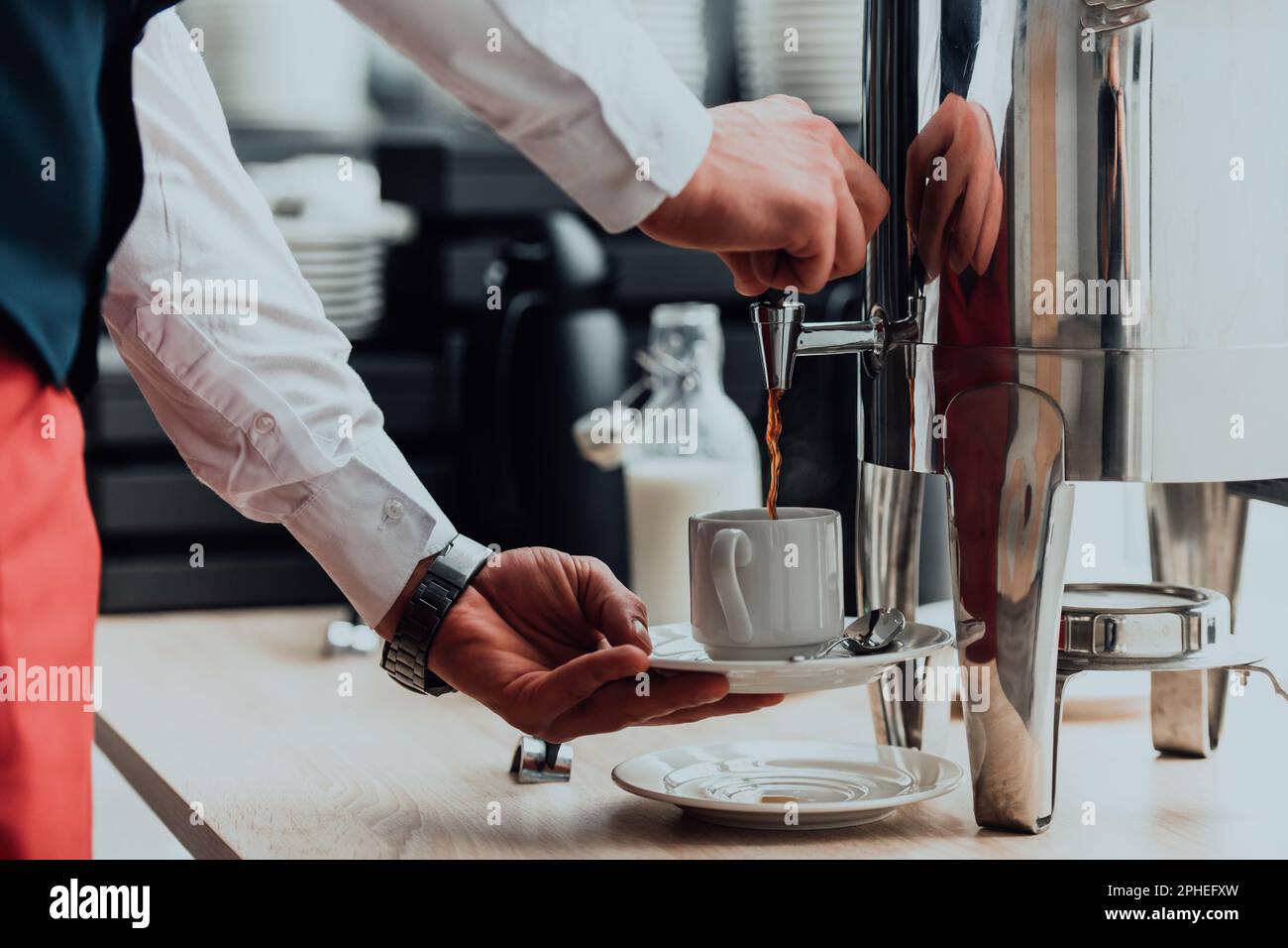 The waiter preparing coffee for hotel guests. Close up photo of service ...