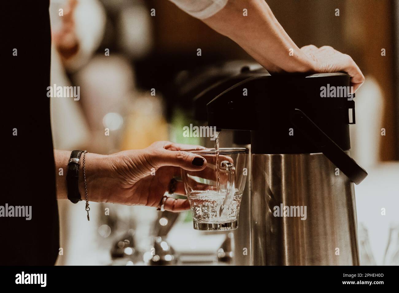 The waiter preparing coffee for hotel guests. Close up photo of service ...