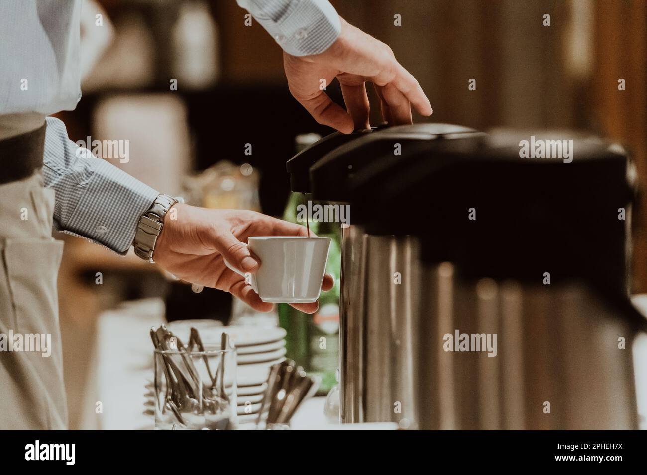 The waiter preparing coffee for hotel guests. Close up photo of service ...
