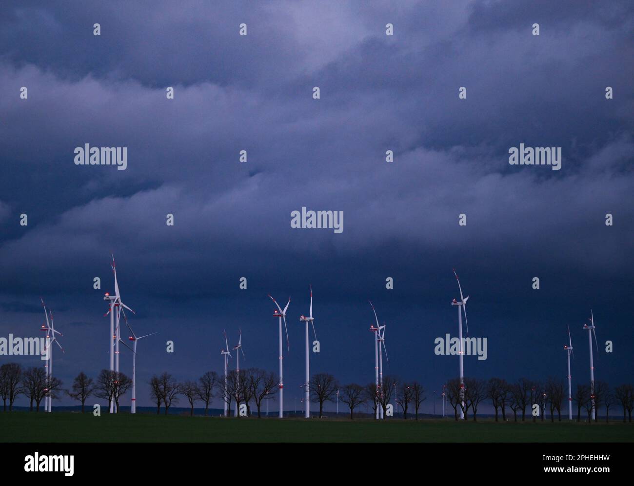 Sieversdorf, Germany. 27th Mar, 2023. Dark clouds pass over the wind ...