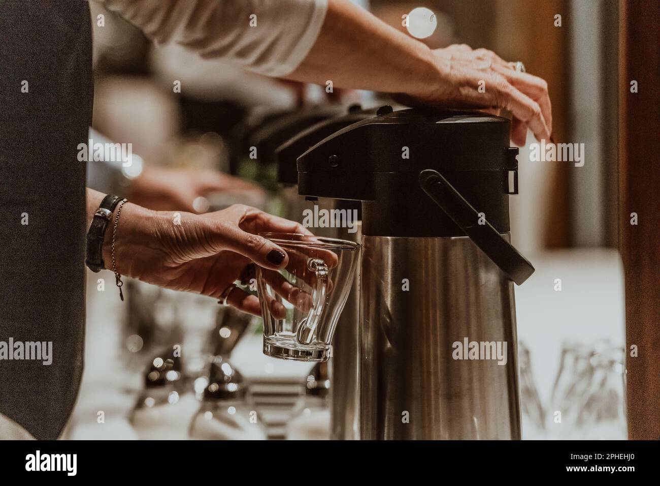 The waiter preparing coffee for hotel guests. Close up photo of service ...