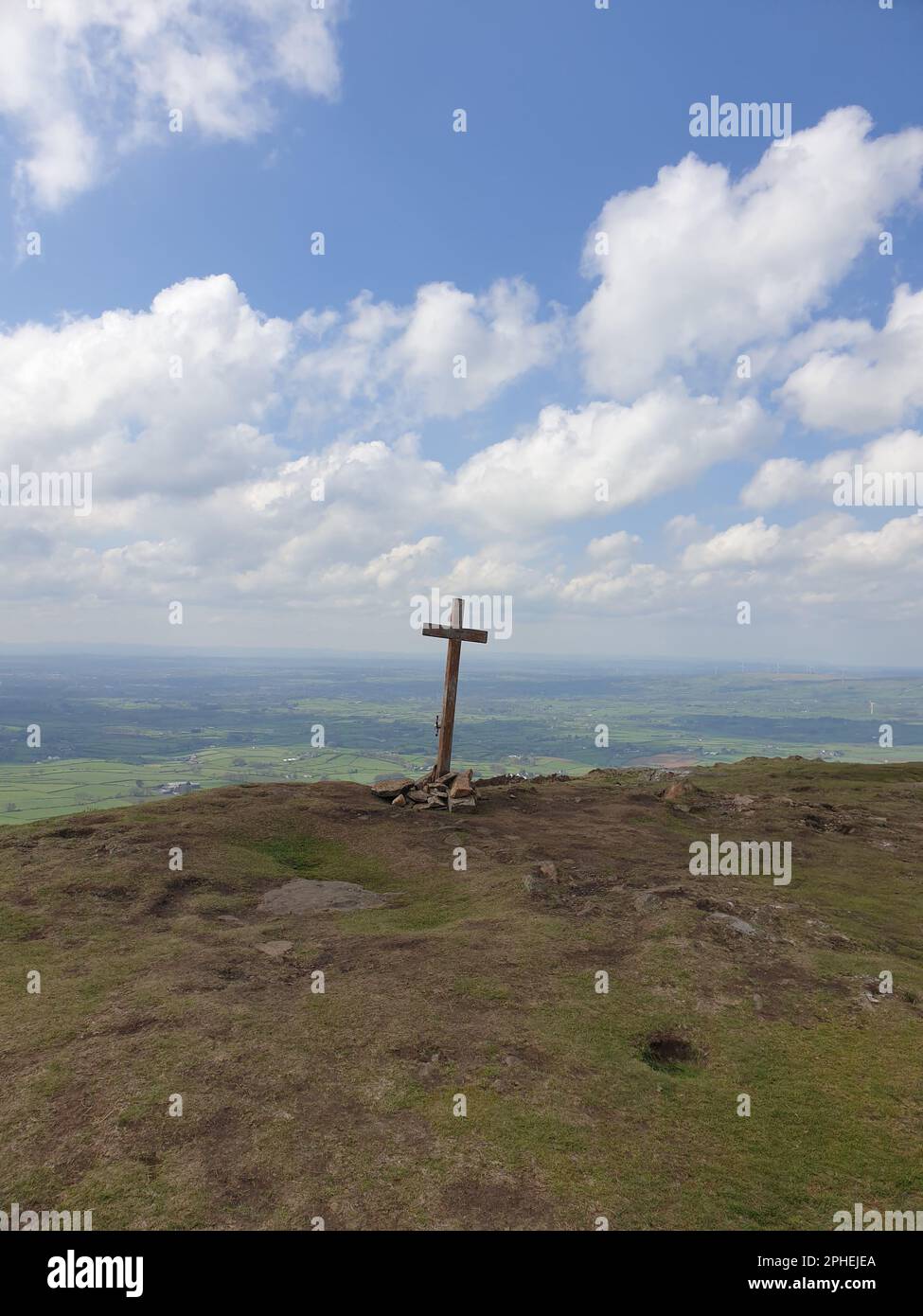 A cross is perched atop a hill in the distance, with a grassy area in ...