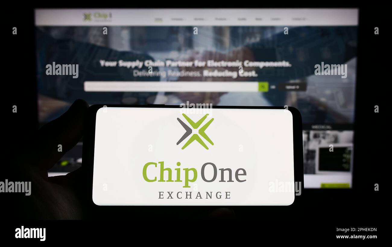 Person holding smartphone with logo of German distribution company Chip ...