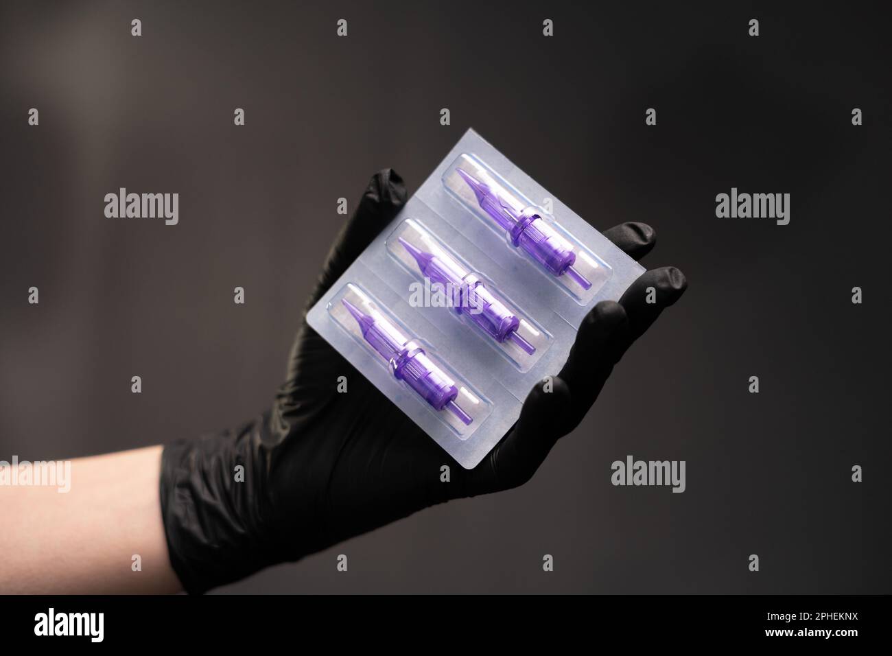 Master of permanent makeup holds disposable needles in her hand over a ... Master of permanent makeup holds disposable needles in her hand over a ...