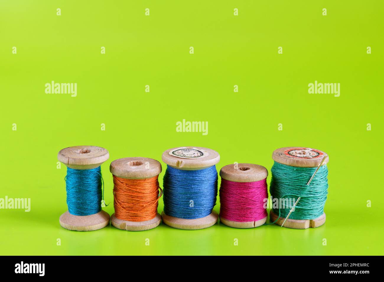 Old wooden reels of thread on green background Stock Photo - Alamy