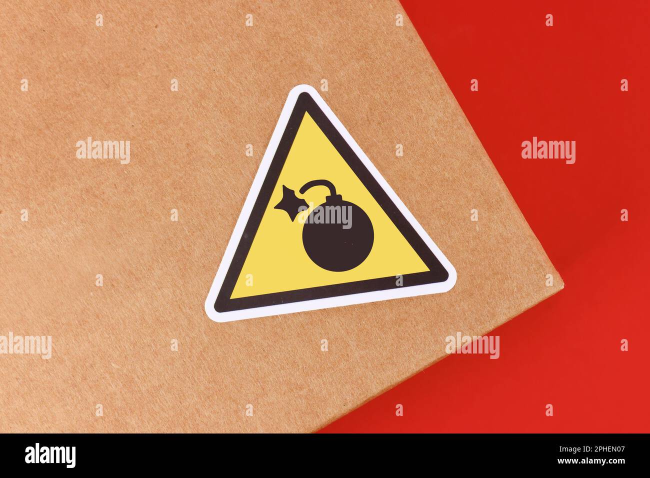 Triangular warning label with bomb icon on parcel Stock Photo - Alamy