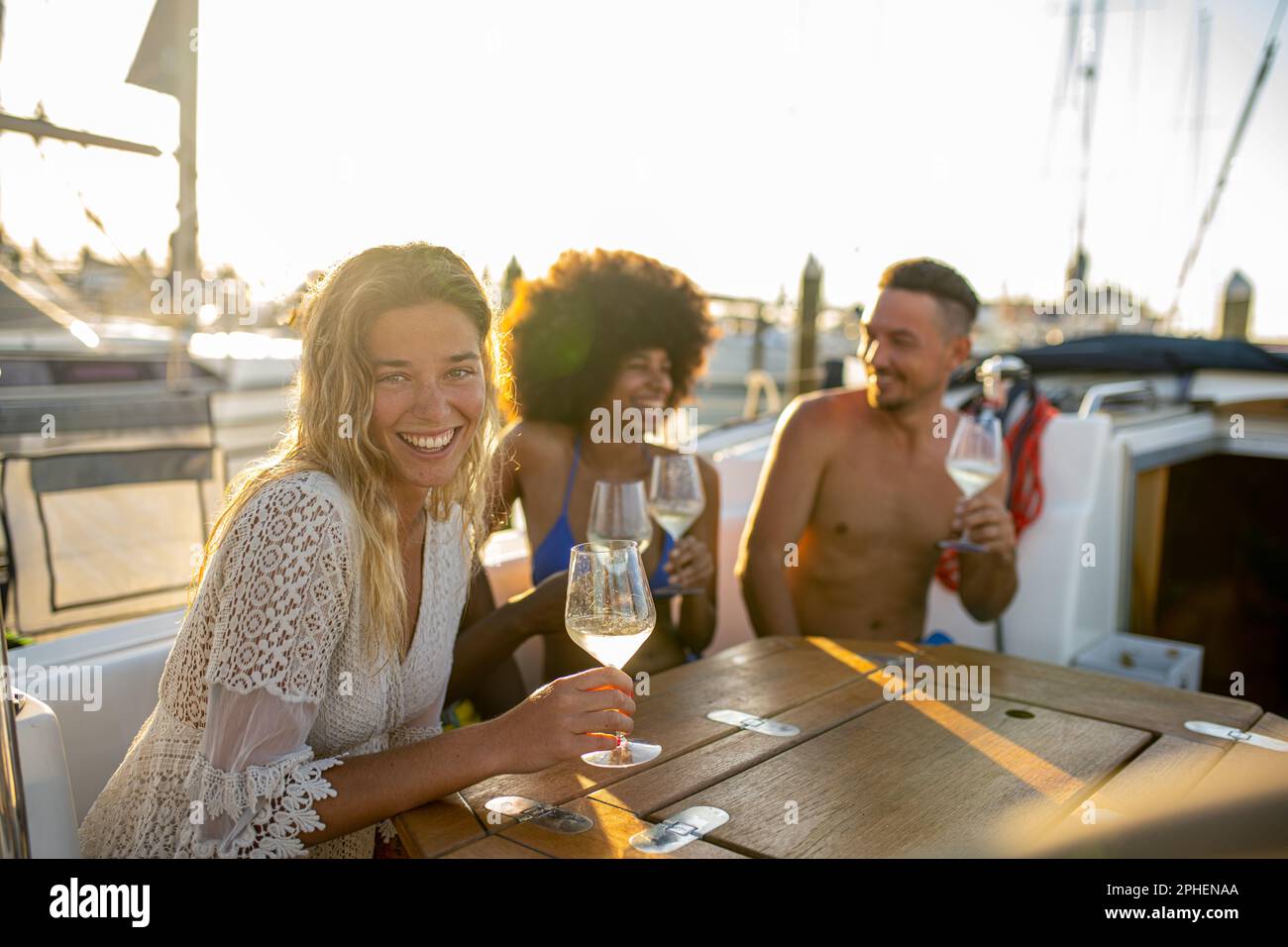 Party moments on a yacht, young blonde woman smiles and looking at the ...