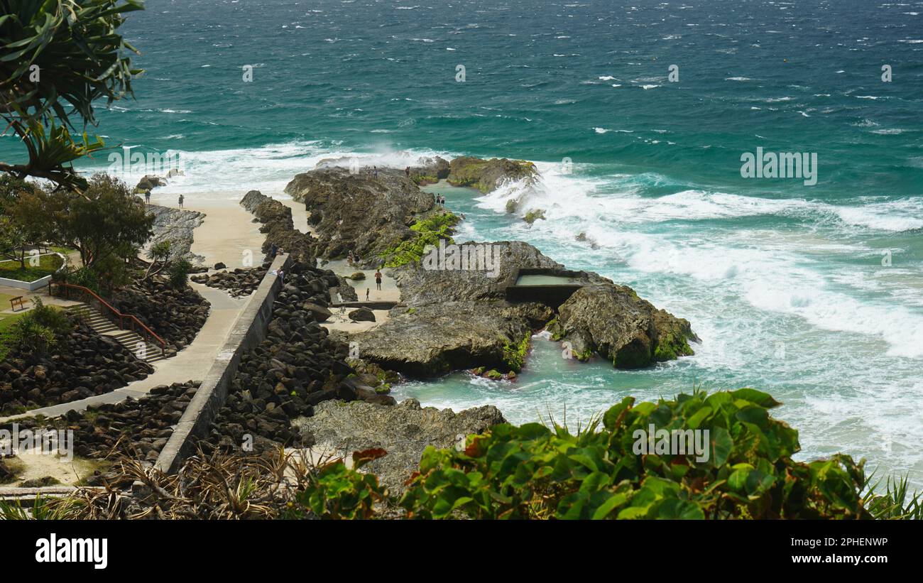 Looking down on rocky coastline and rock pools at Snapper Rocks, at ...