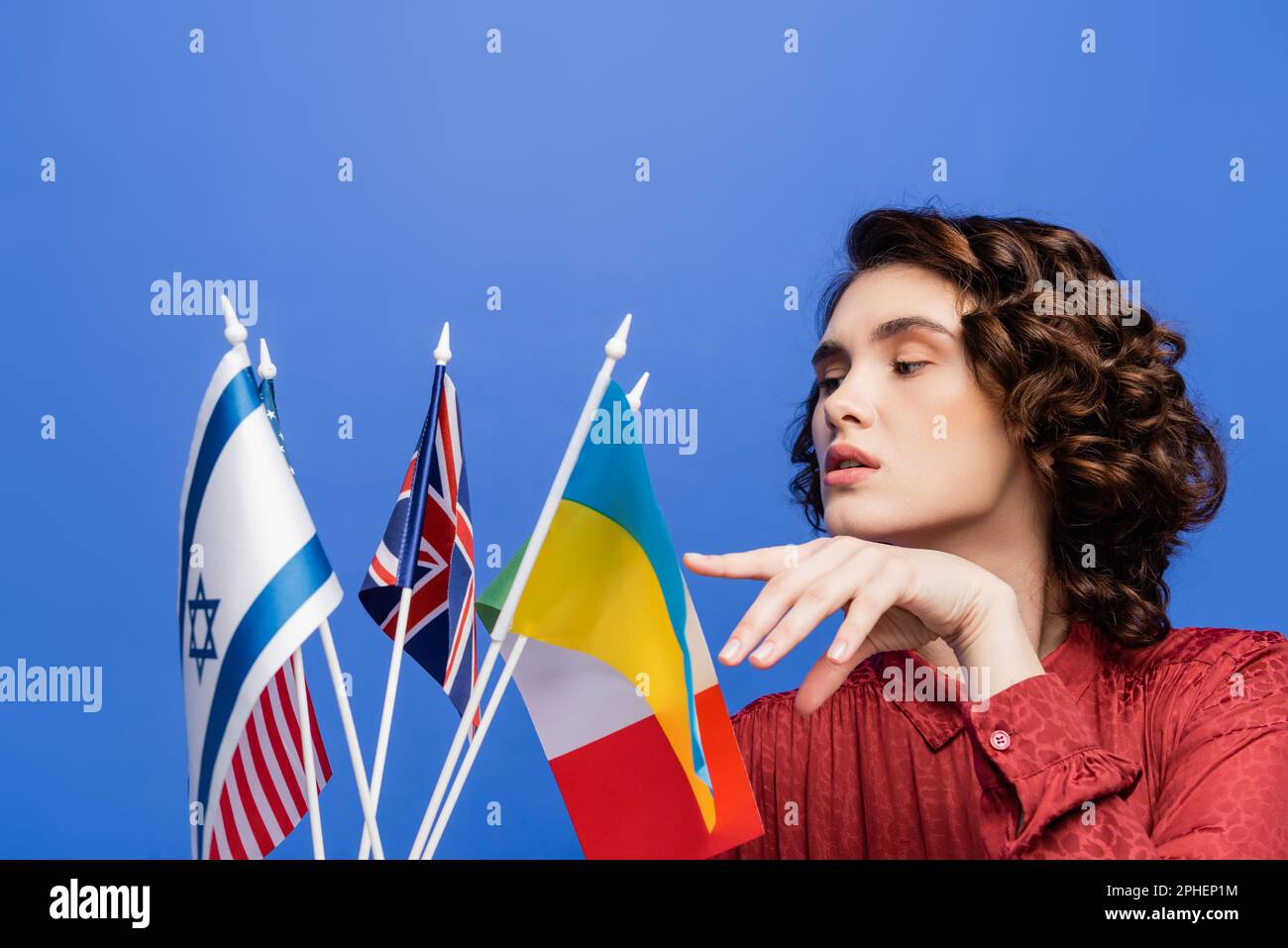 brunette woman pointing at different flags while choosing language to ...