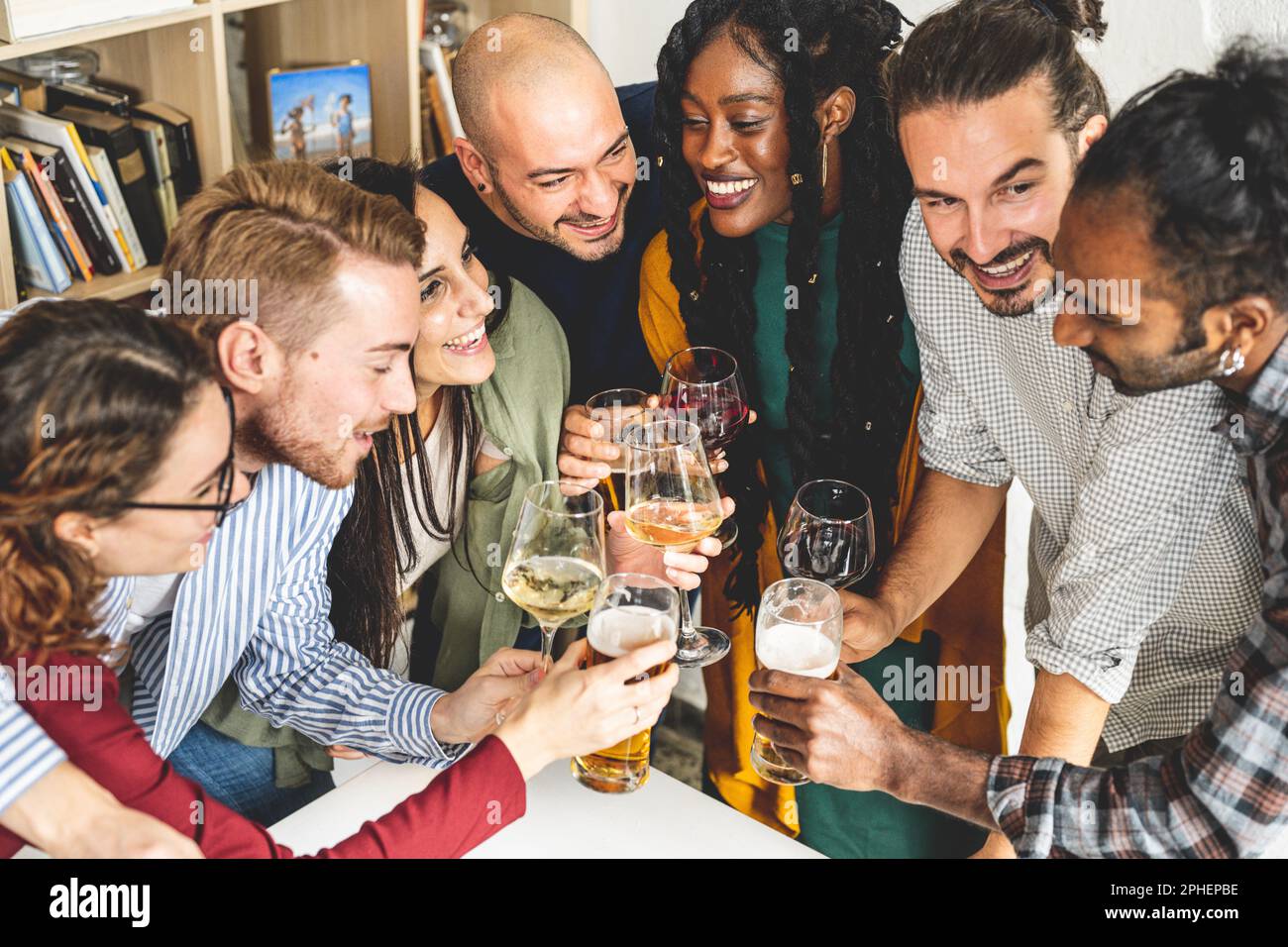 Group of multiracial carefree friends talk, joke and drink at ...