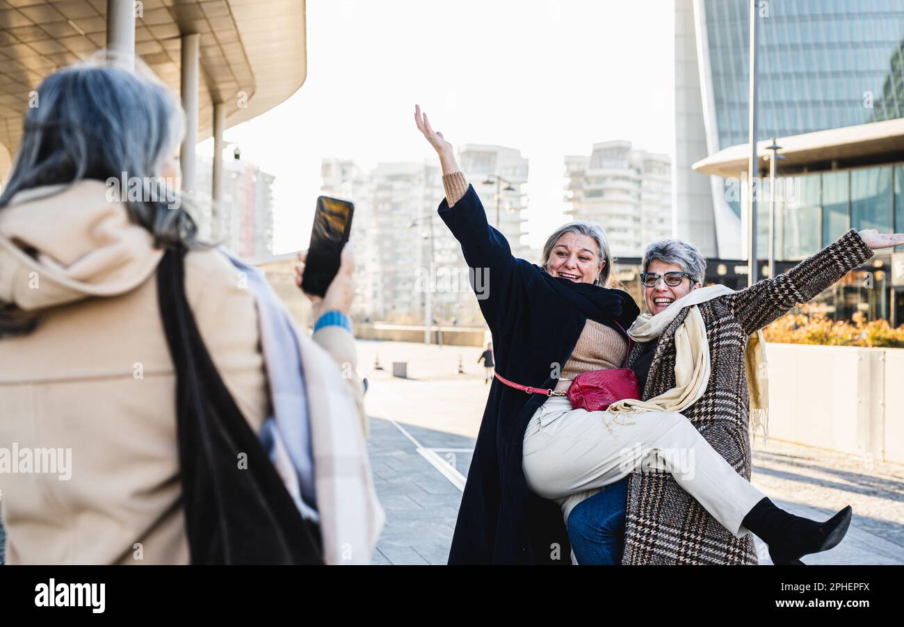 Energetic and vital old ladies enjoy taking pictures during a walk in ...