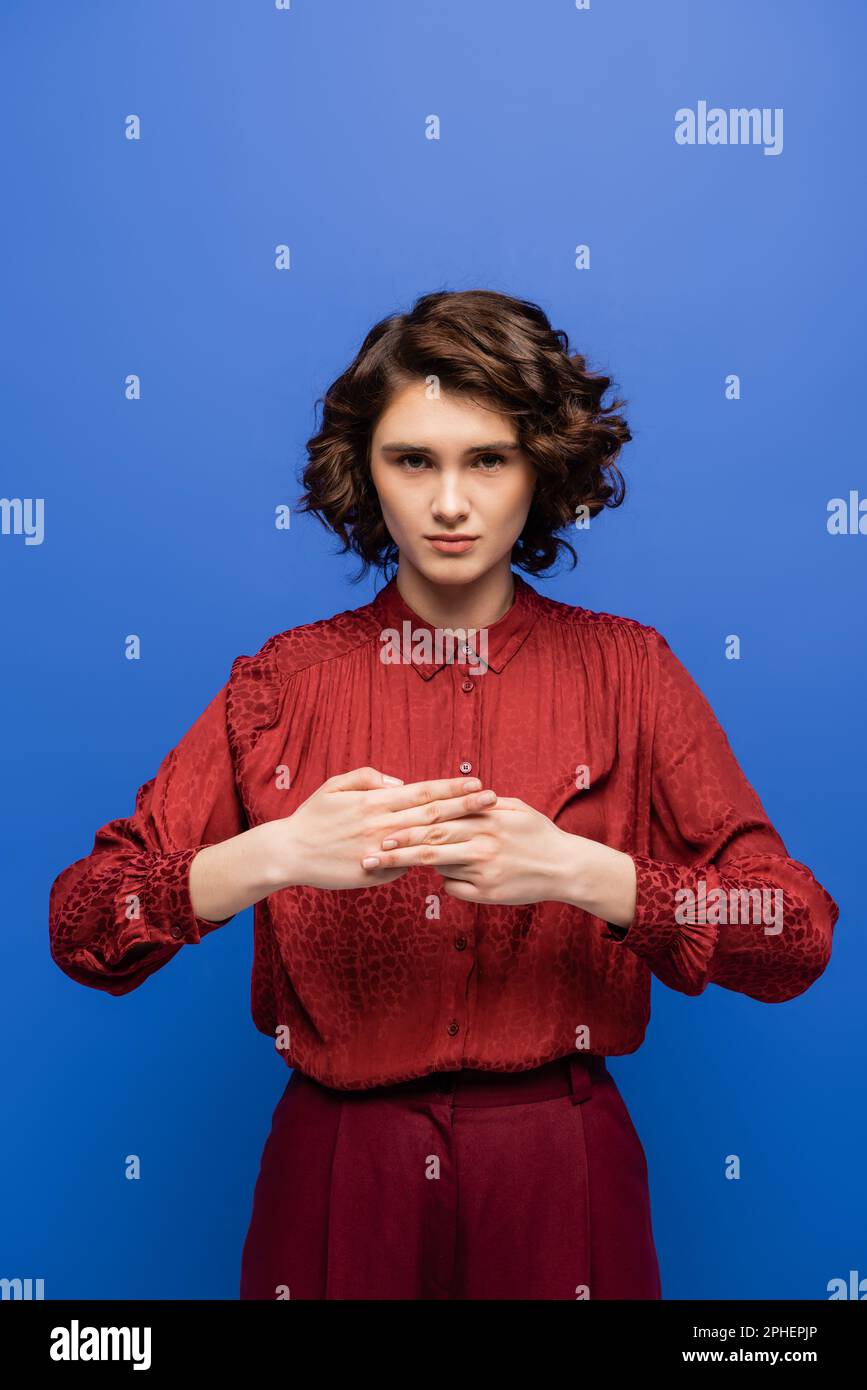 young woman with curly hair showing sign meaning name on sign language ...