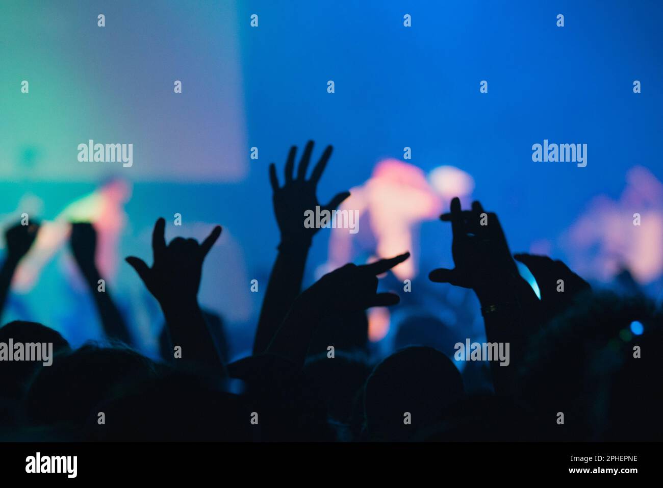 Back view silhouettes of people with hands up against illuminated with ...