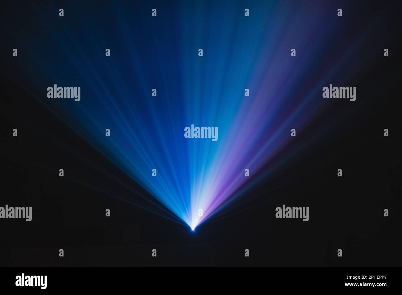 Blue and violet beams of bright laser light shining on black background ...