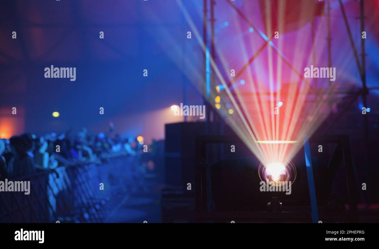 Colorful beams of bright laser light illuminating music venue during ...