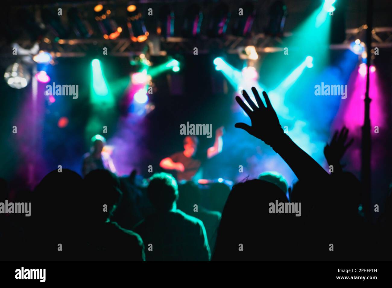 Silhouettes of unrecognizable people holding hands up and having fun ...