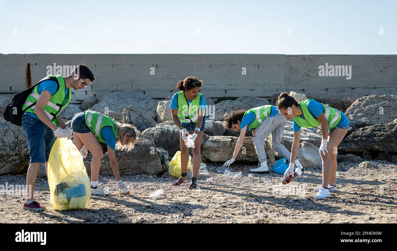 Diverse people cleaning up the beach, volunteers collecting the waste ...
