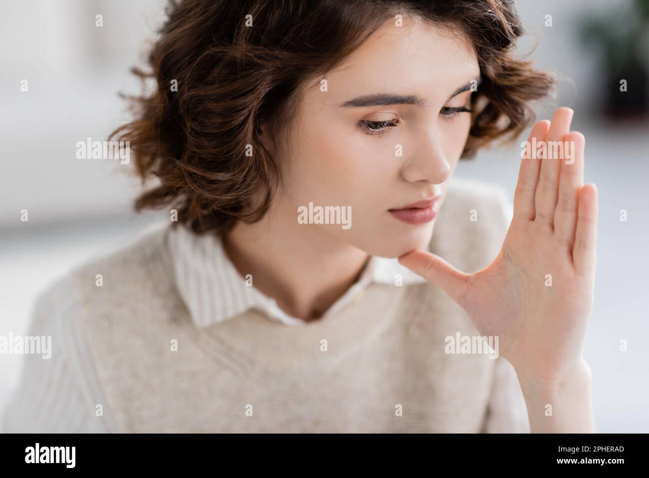 portrait of young brunette woman showing mother or woman gesture on ...