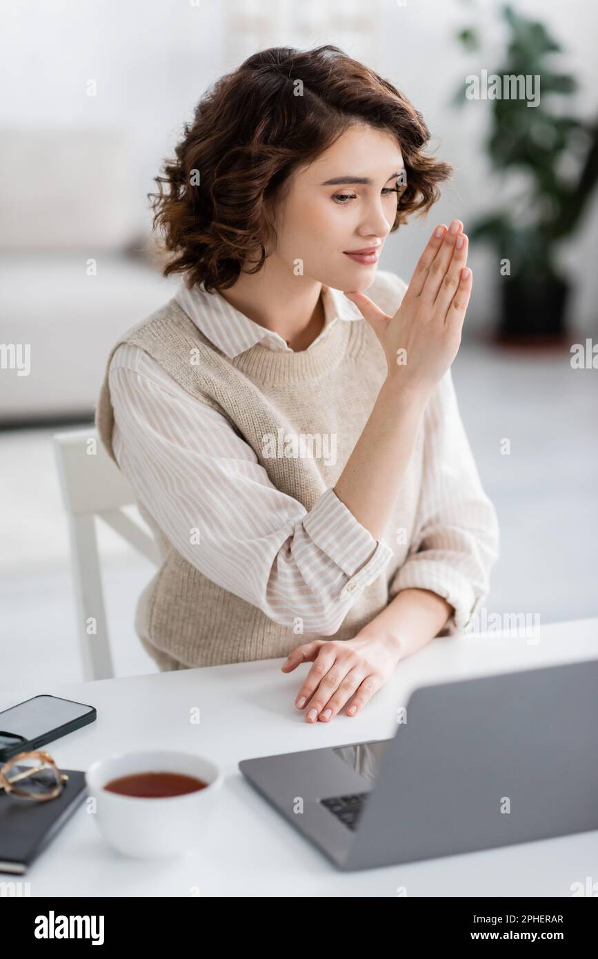 young teacher with curly hair showing mother word on sign language ...