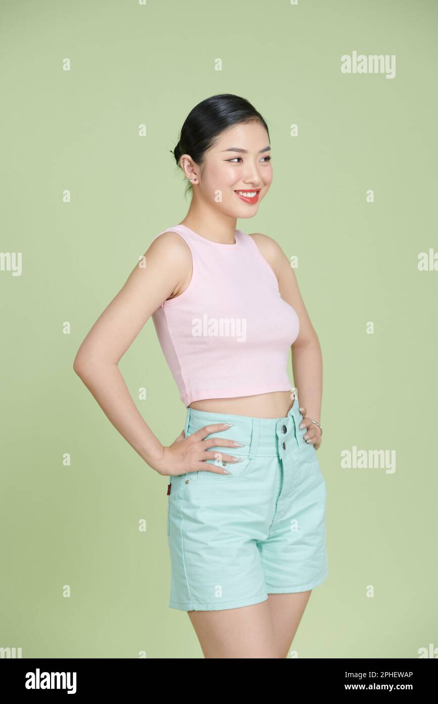 Cute slim feminine young woman in top tank and summer shorts with hands ...