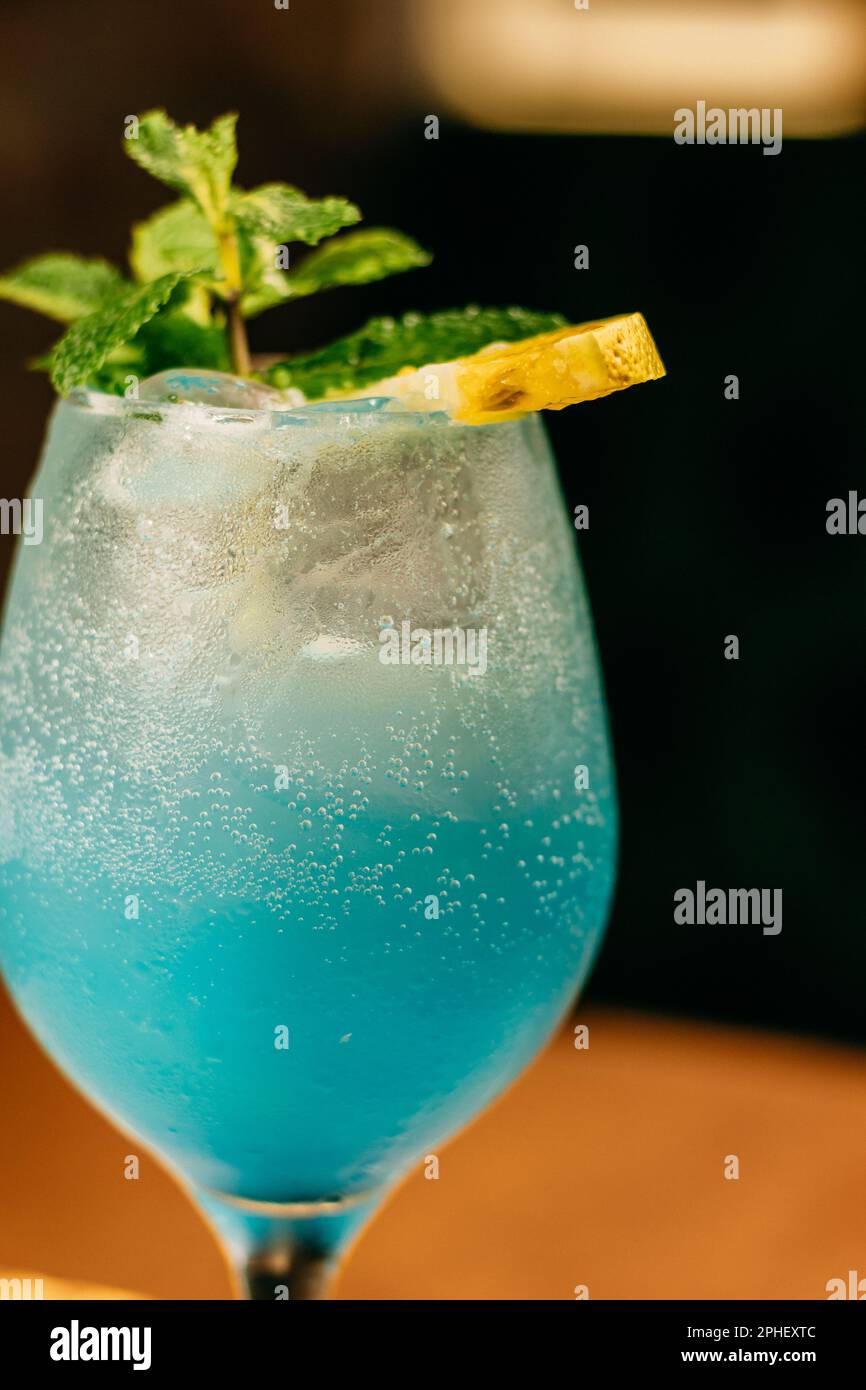 A refreshing vertical close-up of a vibrant blue colored cocktail Stock ...