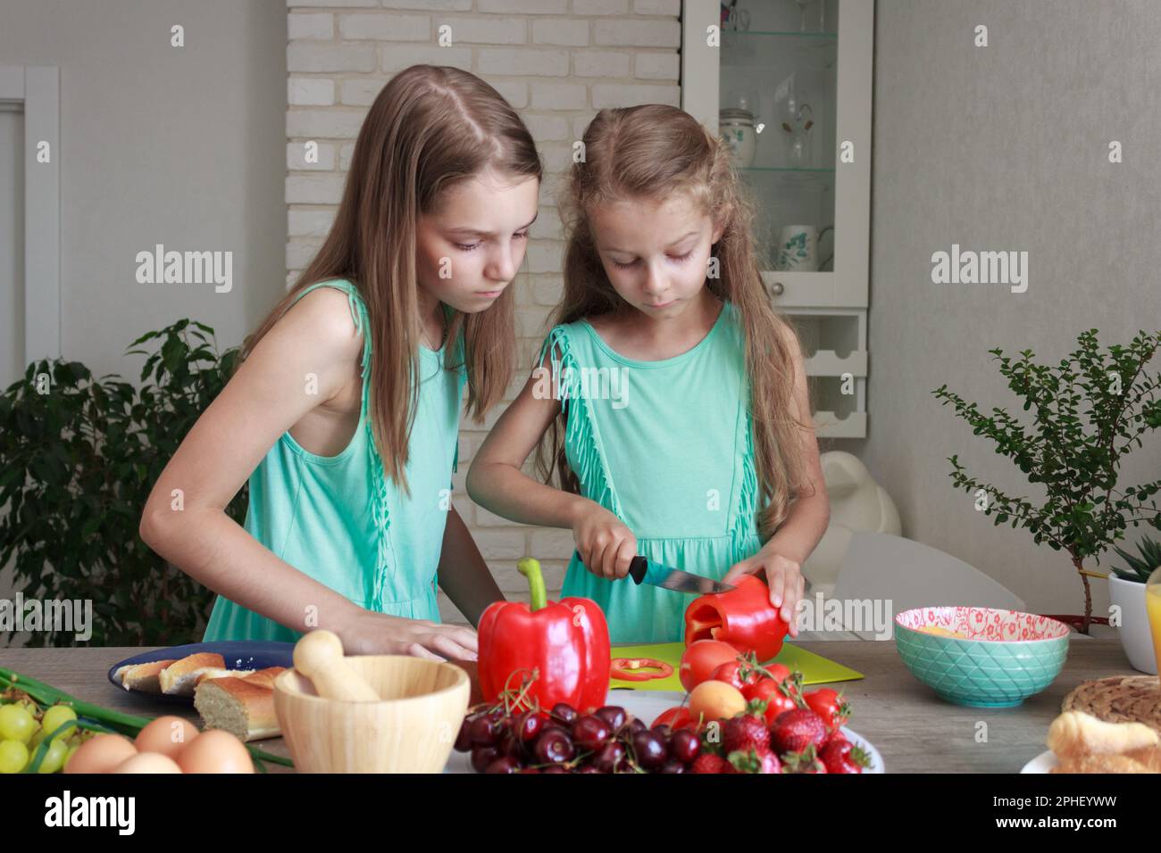 Two girls with long hair are preparing breakfast in the kitchen Stock ...