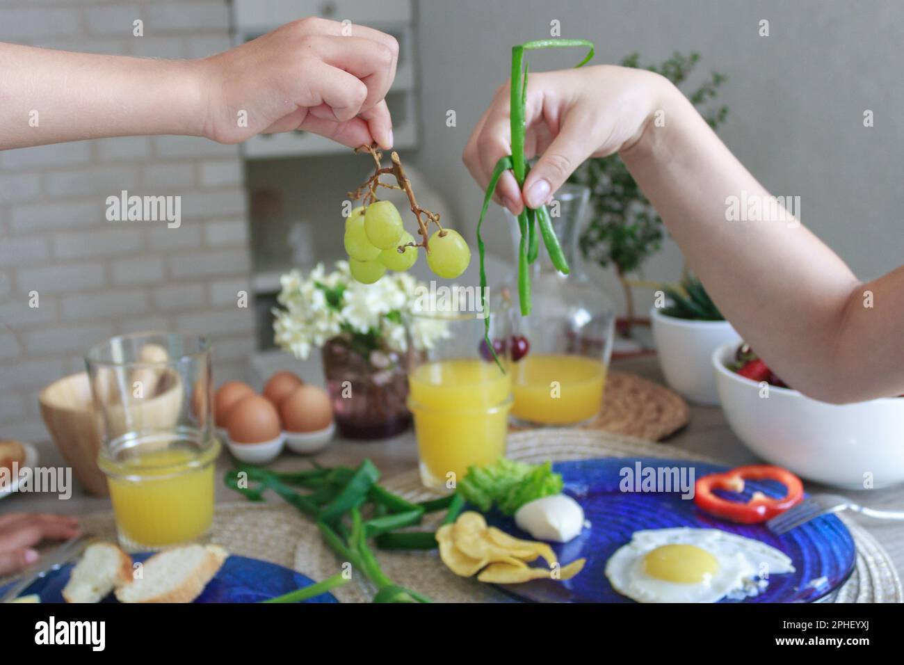 Hands of two people holding food during breakfast Stock Photo - Alamy