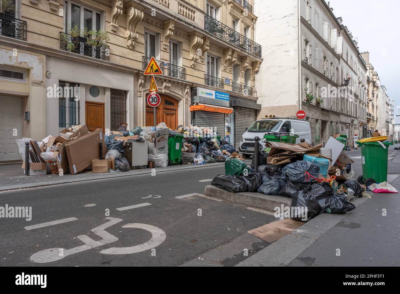 Paris, France - 03 28 2023: Garbage cans left on the public highway ...