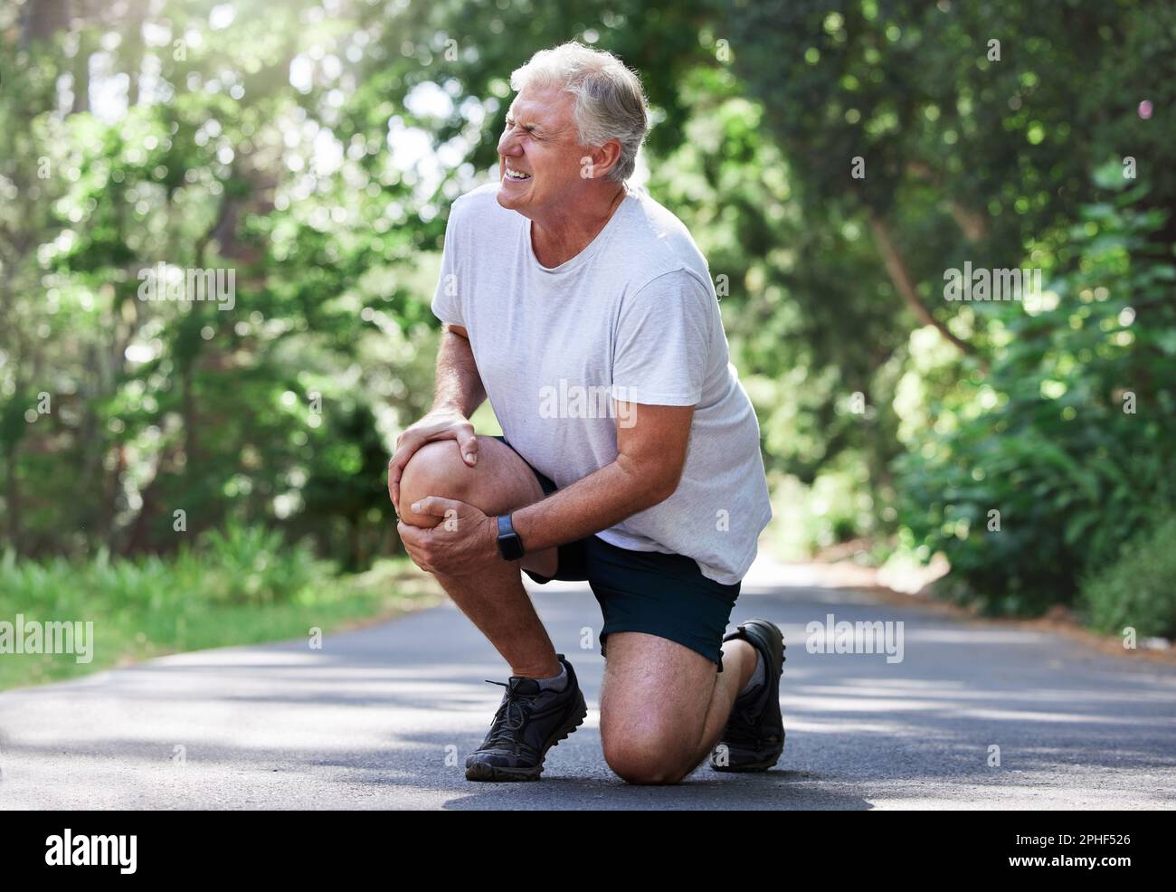 Running, injury and old man with knee pain on path in nature for ...