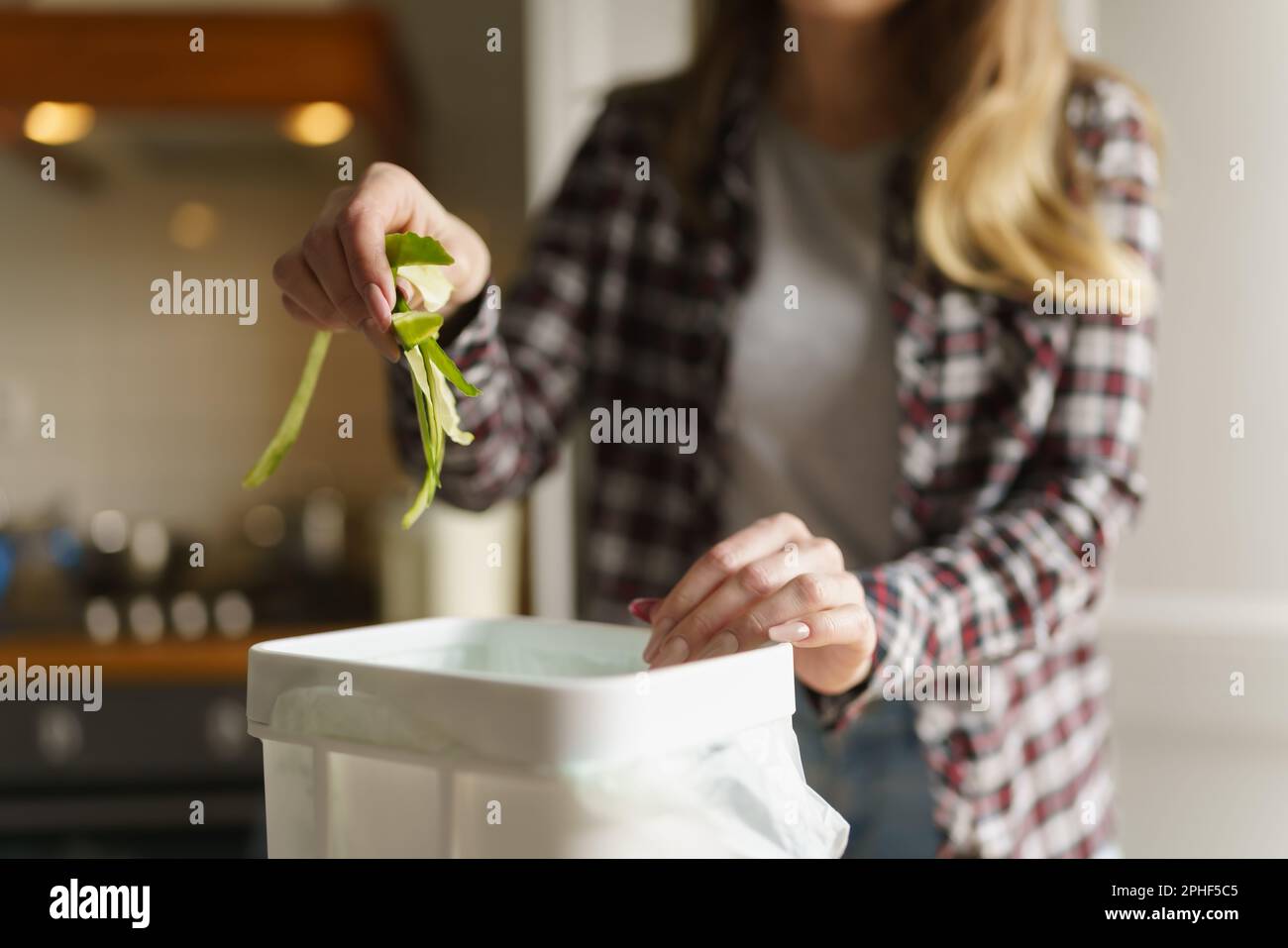 Woman put organic food waste in a compost container. Female person ...