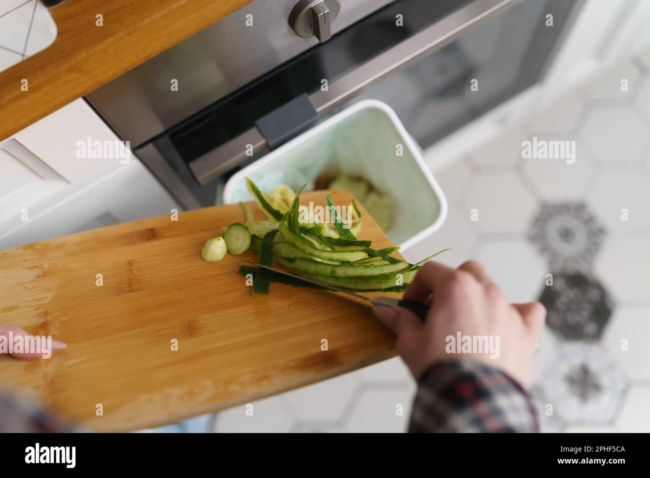Cook throwing cucumber peels in a bokashi container for decomposition ...