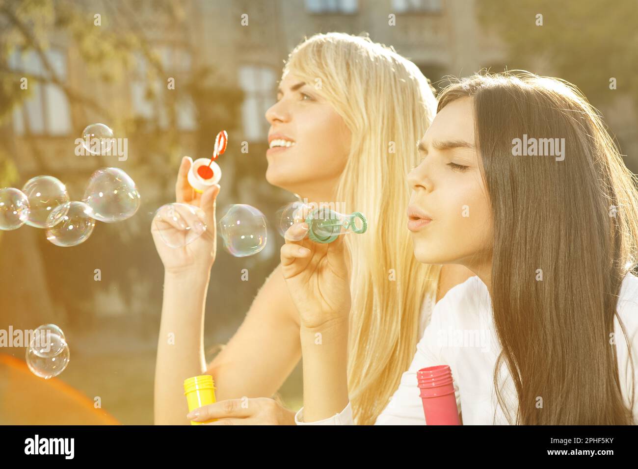 Mother and daughter enjoying blowing bubbles together Stock Photo - Alamy