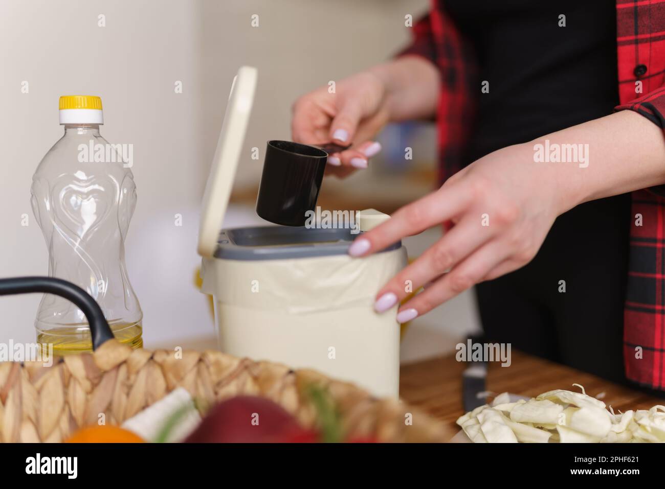 Woman pouring bokashi ferment in a compost bin for recycling. Female ...