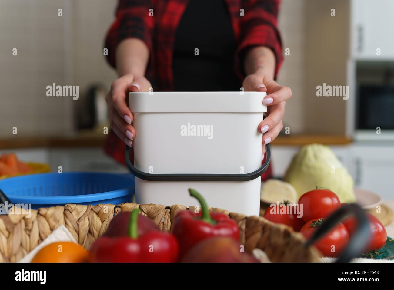 Woman holding compost bin. Female cooking dinner at home and recycling ...