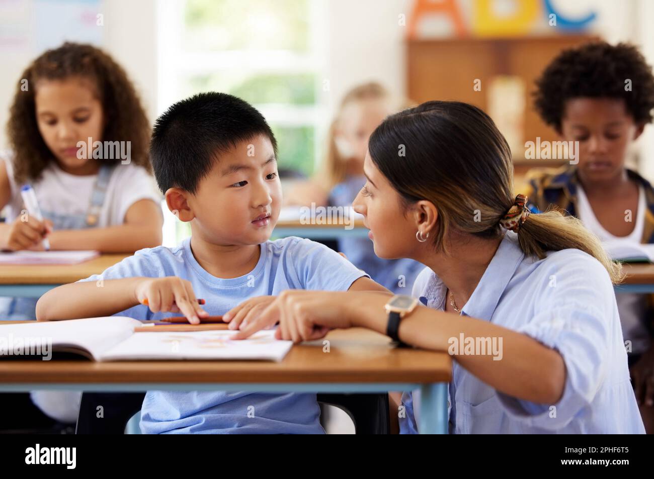 Teacher, learning and helping boy in classroom for knowledge, studying ...
